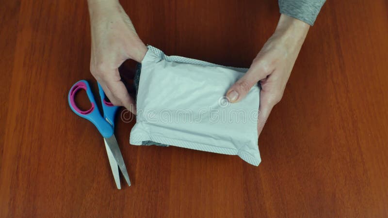 Close-up Female Hands Unpack a Plastic Package from a Postal Parcel ...