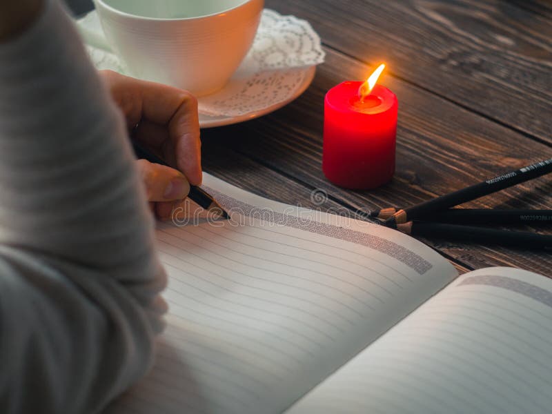 Close Up of Female Hands Writing with Pencil at Cafe with Burning ...
