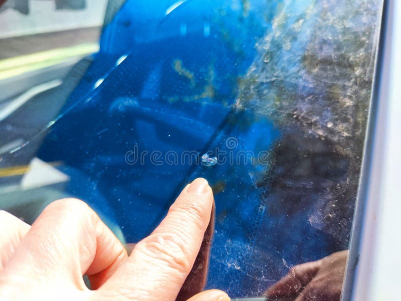 Close-Up of a Finger Pointing at a Chip on a Car Window in Daylight ...