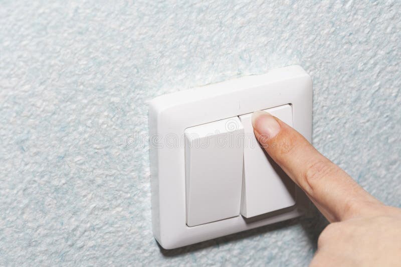 Close Up. a Finger Presses Down on a Single White Light Switch on a ...