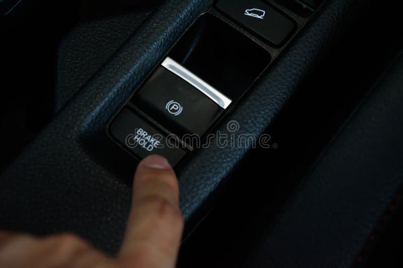Close Up Finger Pressing the Car Brake Button or Button Brake Hold is a ...
