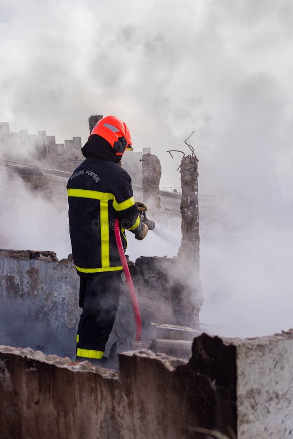 Close-up Firefighter Using a Fire Hose To Put Out a Building Fire Stock ...