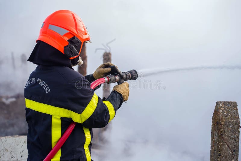 Close-up Firefighter Using a Fire Hose To Put Out a Building Fire Stock ...
