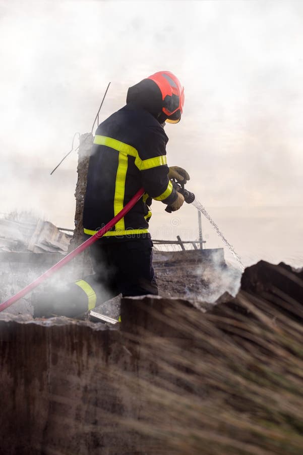 Close-up Firefighter Using a Fire Hose To Put Out a Building Fire Stock ...