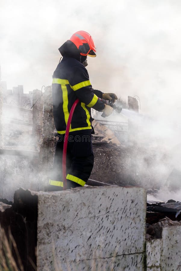 Close-up Firefighter Using a Fire Hose To Put Out a Building Fire Stock ...