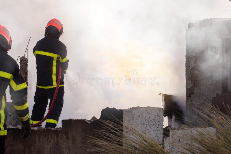 Close-up Firefighter Using a Fire Hose To Put Out a Building Fire Stock ...