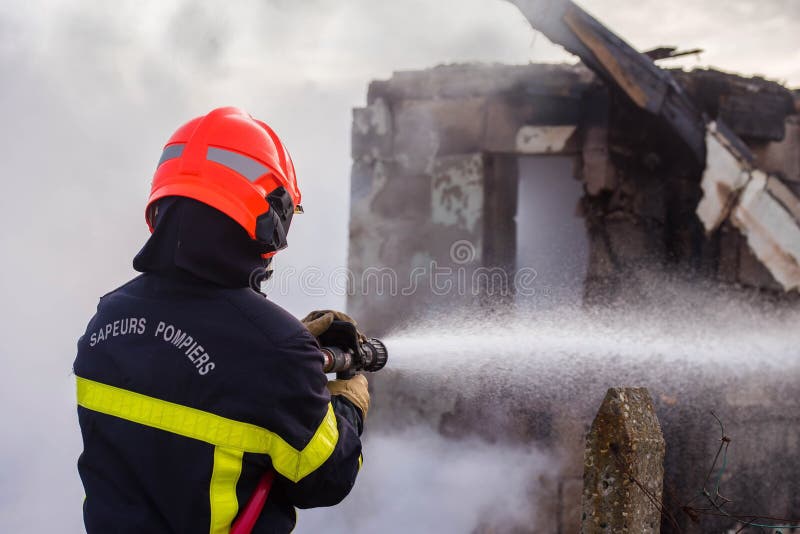 Close-up Firefighter Using a Fire Hose To Put Out a Building Fire Stock ...