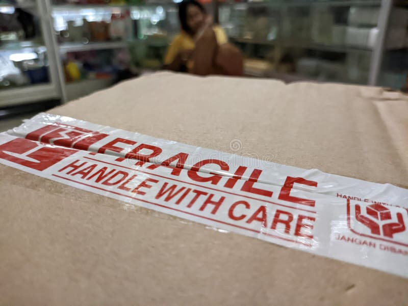 Close Up of Fragile Handle with Care Label Attached To Cardboard Stock ...