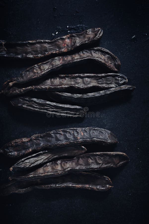 Close-up of Fresh Seed Pods on a Black Surface with Water Droplets and ...