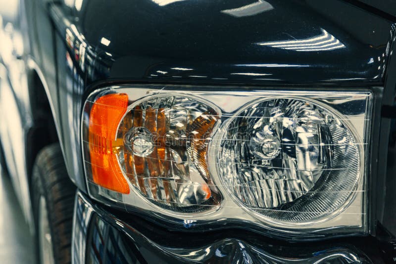 Close-up of the Front Headlights of a Retro Black Car in a Showroom or ...