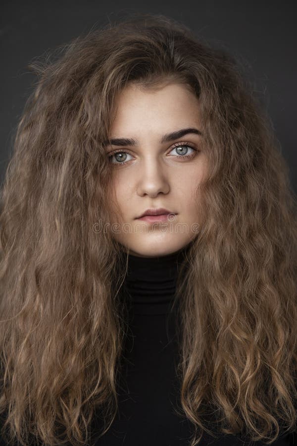 Close Up Front Portrait Of A Young Woman With Curly Hair Wear Black