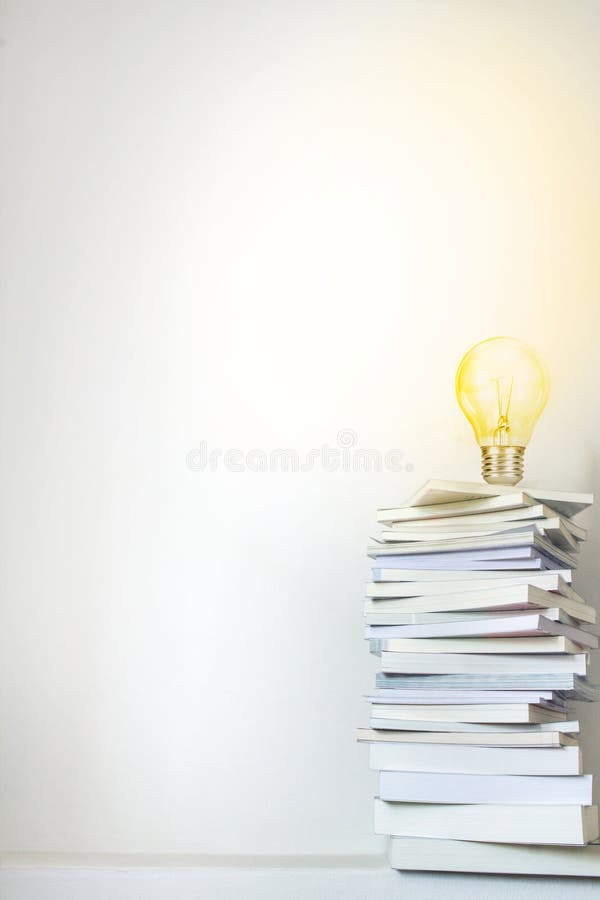 Close Up Glowing Light Bulb on Book Stacked with Concrete Wall Stock ...