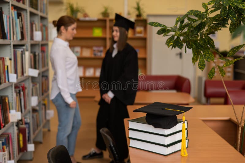 Graduation Cap on a Stack of Books in the Library. Stock Image - Image ...
