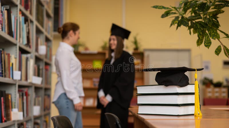 Graduation Cap on a Stack of Books in the Library. Stock Image - Image ...