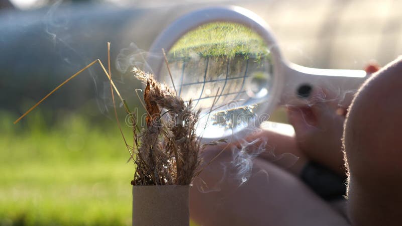 Close-up Grass Smokes from Sunlight through Magnifying Glass. Solar ...