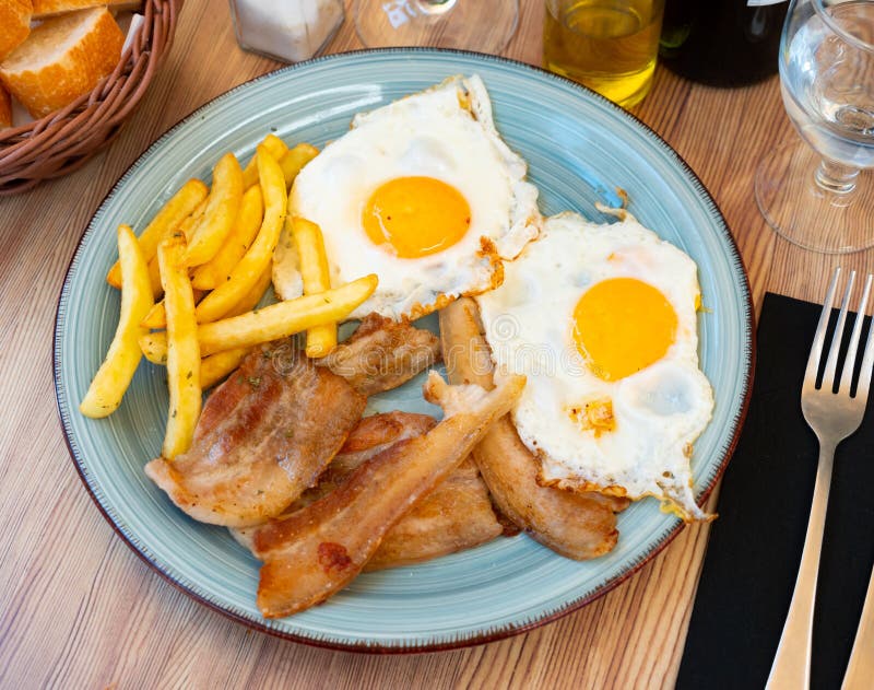 Close Up of Grilled Bacon with Fried Potato and Egg Served on Blue ...