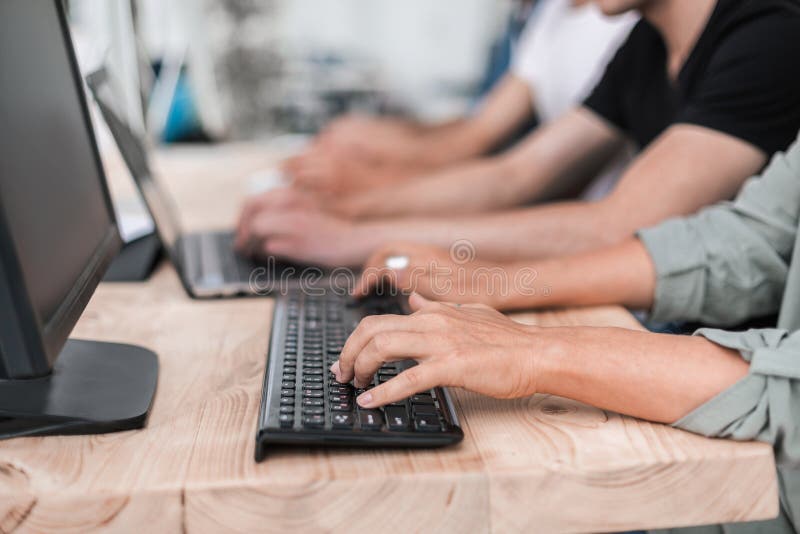 Close Up. a Group of Employees Sitting at a Table in a Computer Room ...