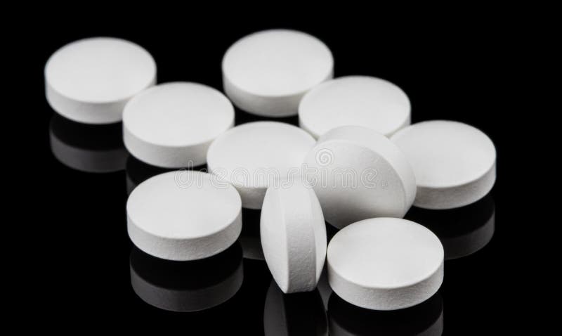 Close Up on a Group of Round Shape White Pill on the Dark Background ...