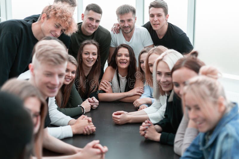 Group of Young People Sitting at a Large Table Stock Image - Image of ...