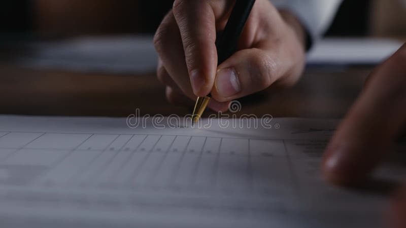 Close-up of a Guy Writing Down a Signature on a Piece of Paper in a ...