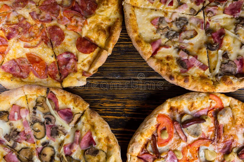 Close Up of Half of Four Different Pizzas on Wooden Table Stock Image ...