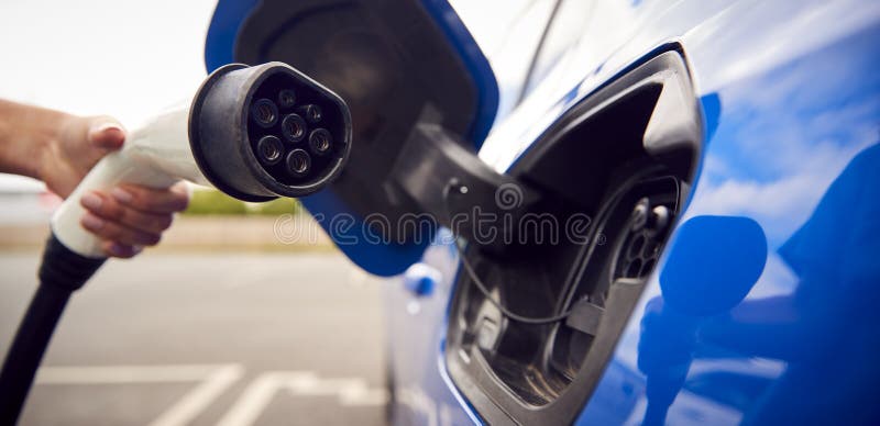 Close Up of Hand Attaching Charging Cable To Environmentally Friendly ...