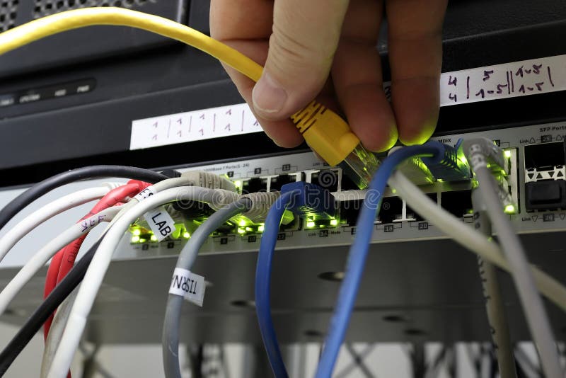 Close-up of a Hand that Connects a UTP Cable To the Switch. View from ...