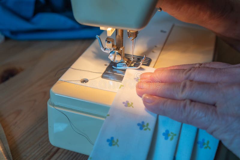 A Close Up of a Hand Controlling the Fabric and the Needle of a Sewing ...