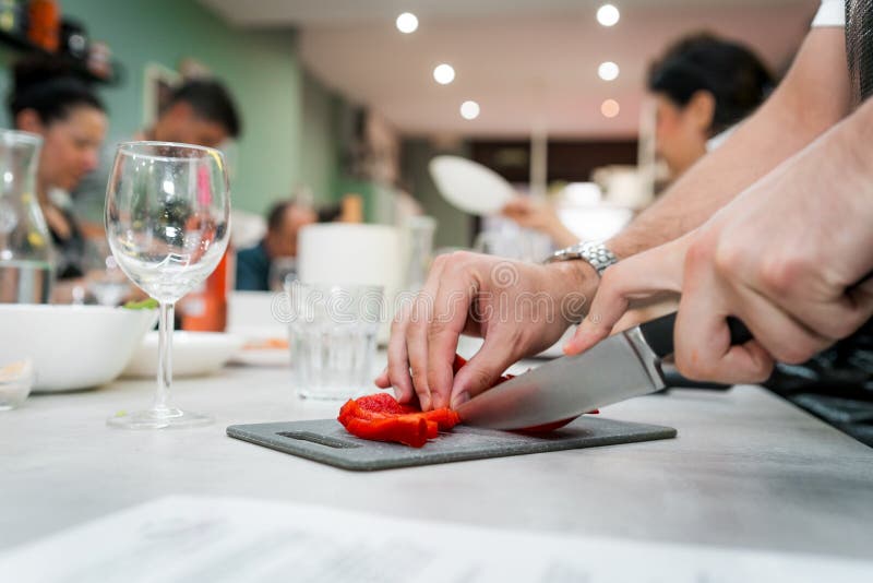 Close Up of Hand Cutting Vegetebles during Cooking Class with Group of People Stock Photo ...