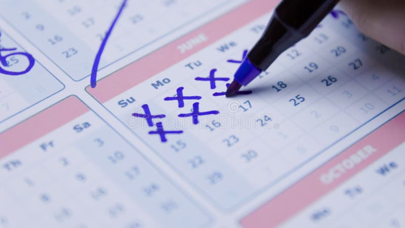 Close-up Shot of Calendar Dates Being Marked Off by Hand Using a Purple ...