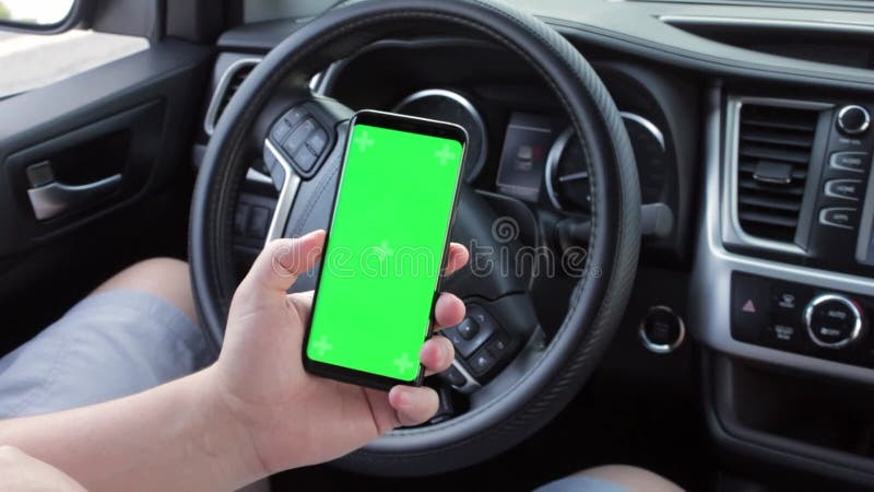 Close Up Hand of the Driver in Car Holding a Smartphone with a Green ...