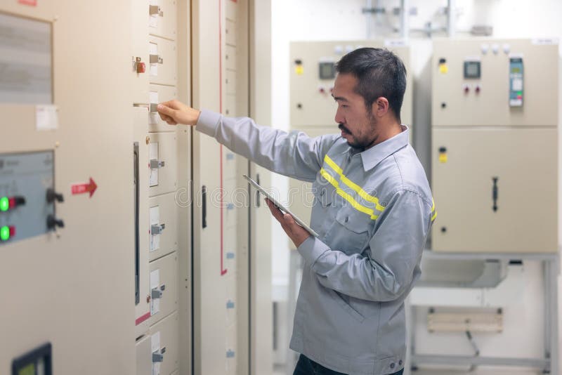 A Male Electrician Works in a Switchboard Electrical Terminal Junction ...