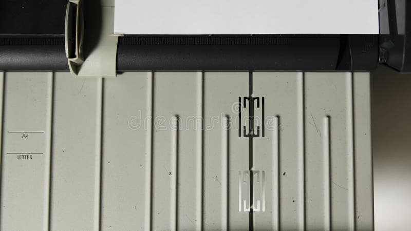 Close-up of Hand Feeding White Paper into an Office Printer for Smooth ...