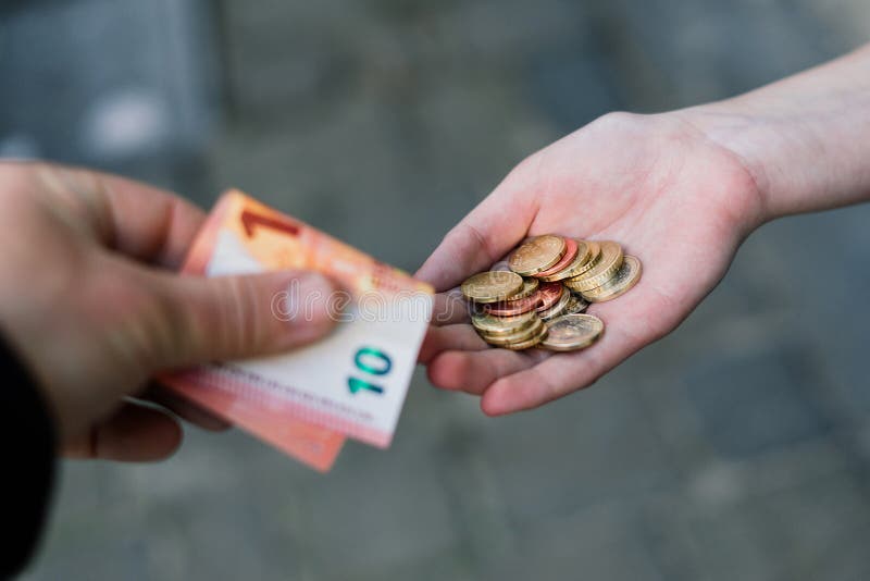 Close-up of a Hand Giving Coins To Another Hand with Banknotes Stock ...