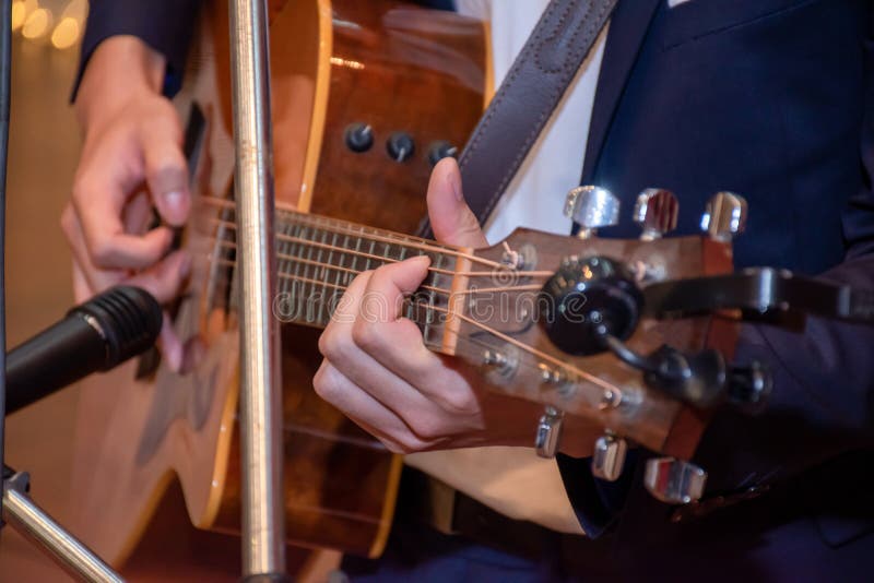 Close-up on Hand, a Handsome Young Man Plays the Guitar for a Live ...