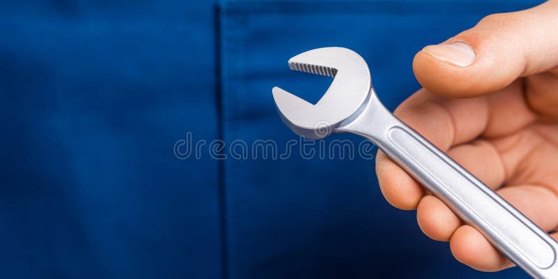 Close-up of a Hand Holding an Adjustable Wrench Against a Blue ...
