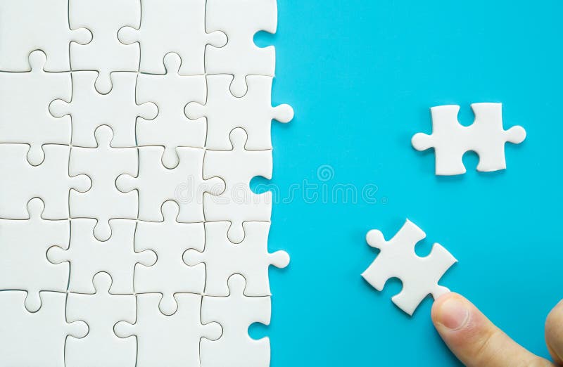 Close Up Hand Holding and Playing Jigsaw Game Incomplete. White Part of ...