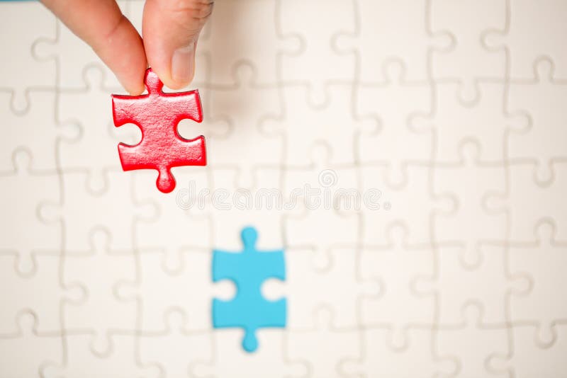 Close Up Hand Holding and Playing Jigsaw Game Incomplete. White Part of ...