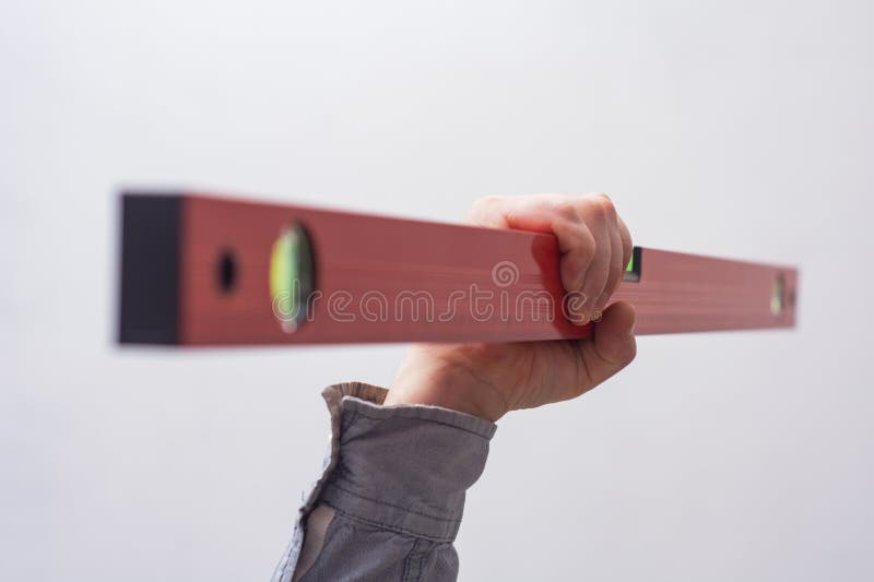 Close-up of a Hand Holding a Red Construction Level. Tool for DIY ...