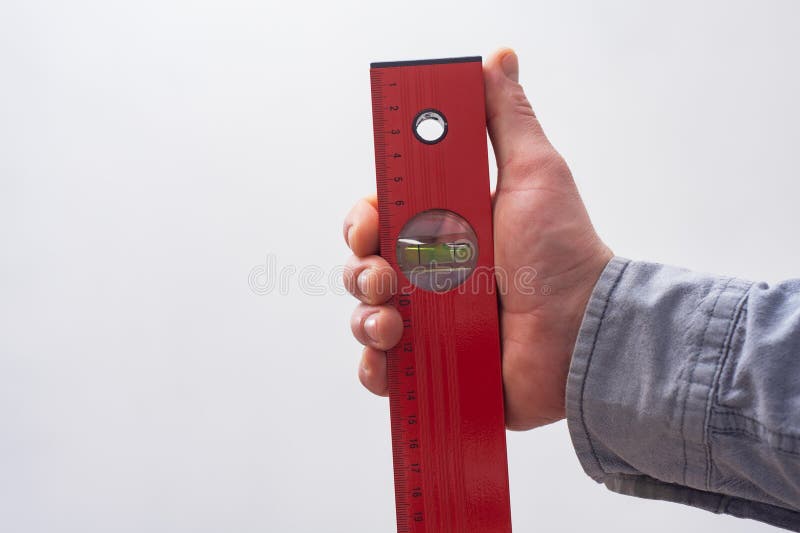 Close-up of a Hand Holding a Red Construction Level. Tool for DIY ...