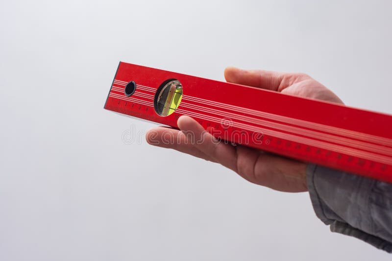 Close-up of a Hand Holding a Red Construction Level. Tool for DIY ...