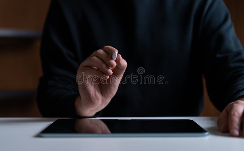 Close-up of Hand Holding Stylus Above Digital Tablet on Table in Dark ...
