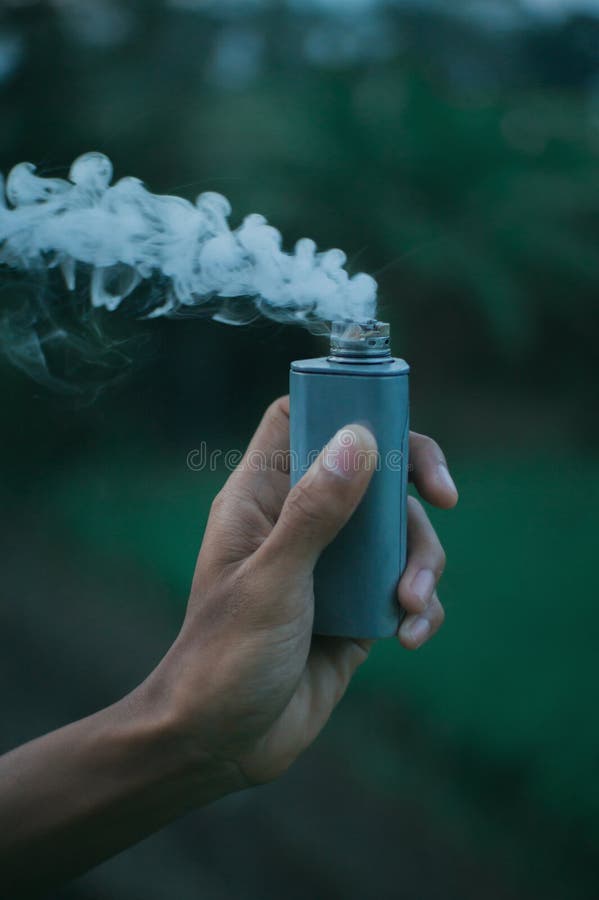 Close-Up Hand is Holding a Vape that is Emitting Smoke Stock Photo ...