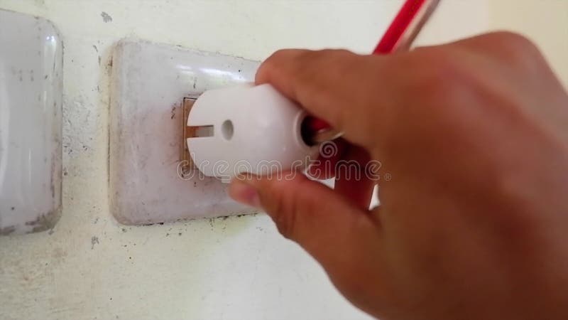 Close Up of a Hand Inserting a Safety Plug into a Wall Socket Stock ...