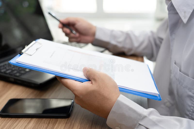 Close Up Hand a Man Hold Graph Data Document and Use Laptop Computer ...
