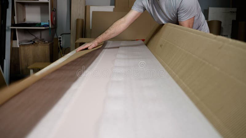 Close-up of a Hand Packing a Cardboard Box with Tape in a Warehouse ...