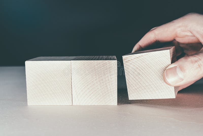 Close-up of Hand Placing Three Wooden Blocks on Table Stock Image ...