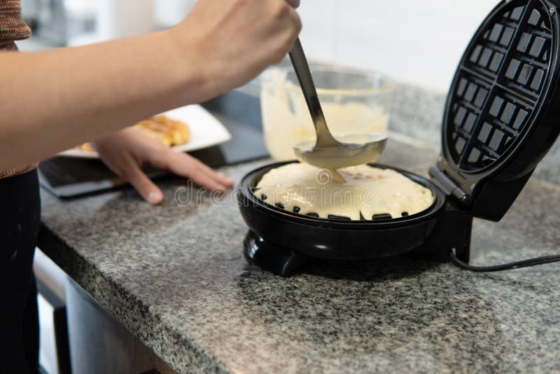 Close-up of a Hand Placing Waffle Batter in the Waffle Iron Stock Image ...