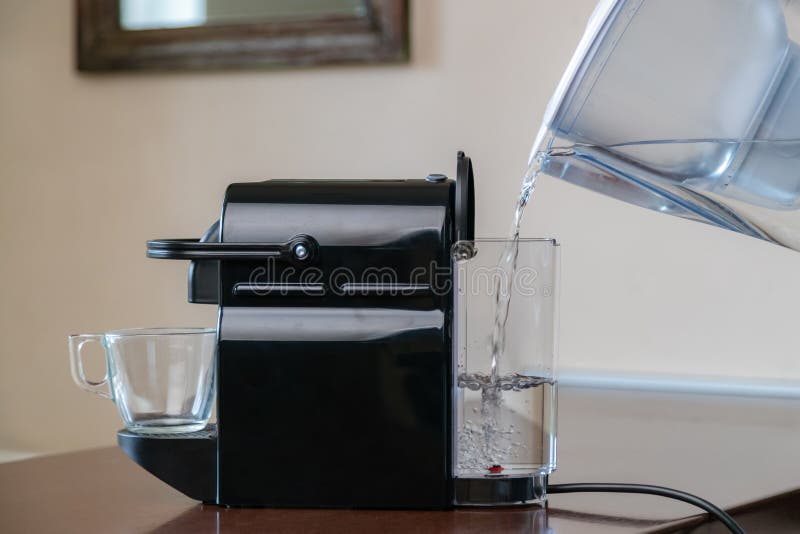Close Up Of Hand Pouring Pure Filtered Water Into Capsule Coffee ...