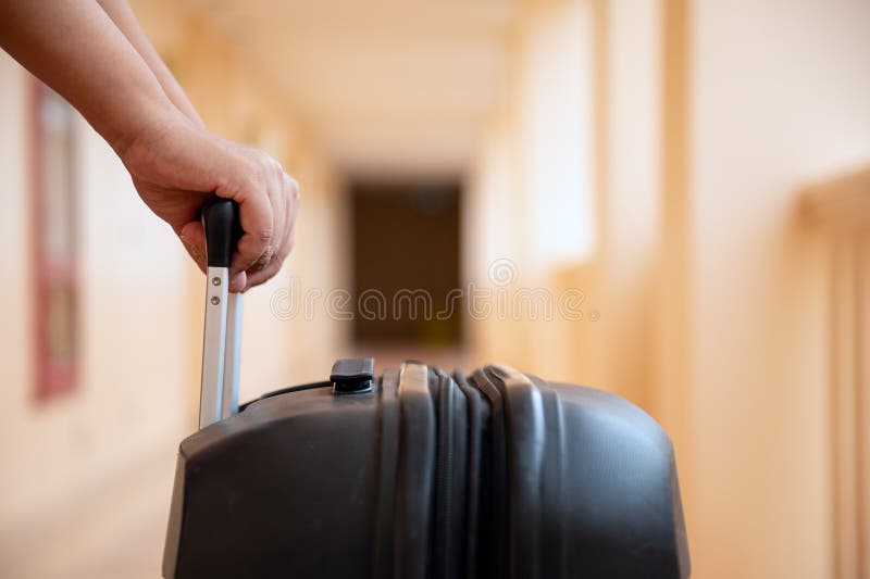 Close-up of Hand Pulling Black Suitcase with Retractable Handle Down ...